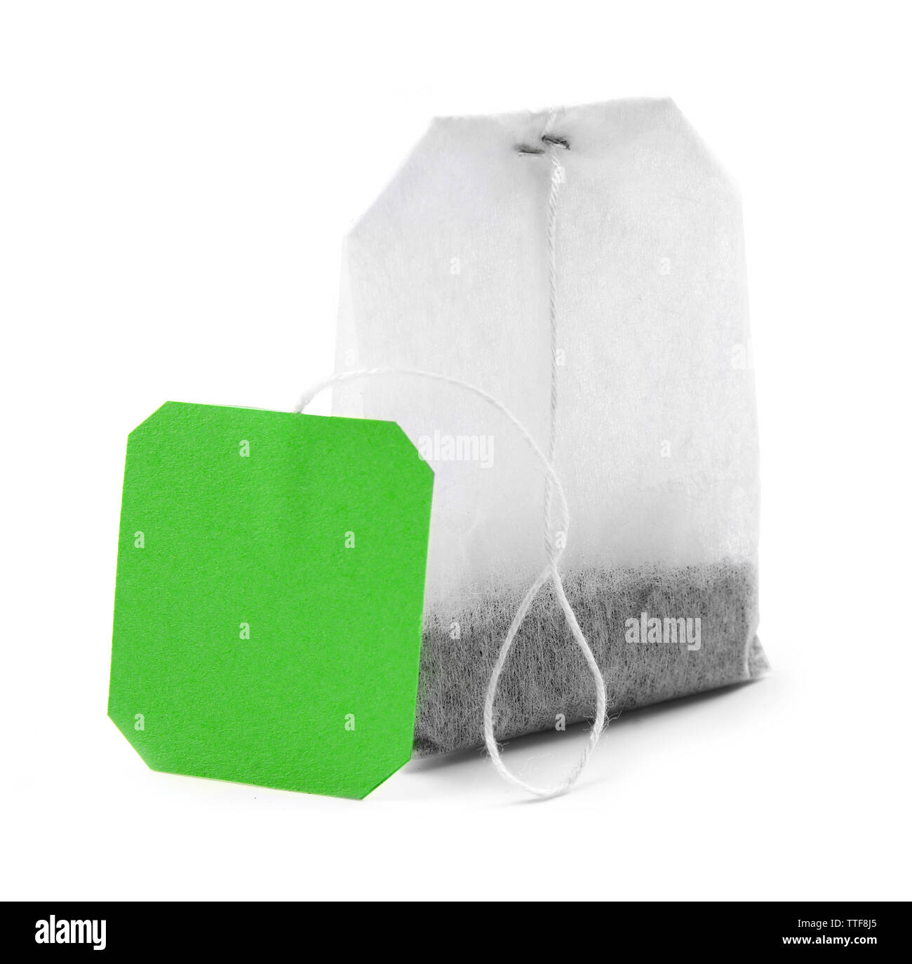 Teabag with green label isolated on white background Stock Photo - Alamy
