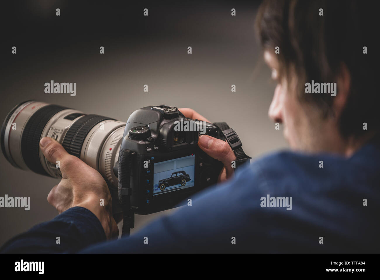 Over the shoulder view of photographer taking photographs with DSLR ...