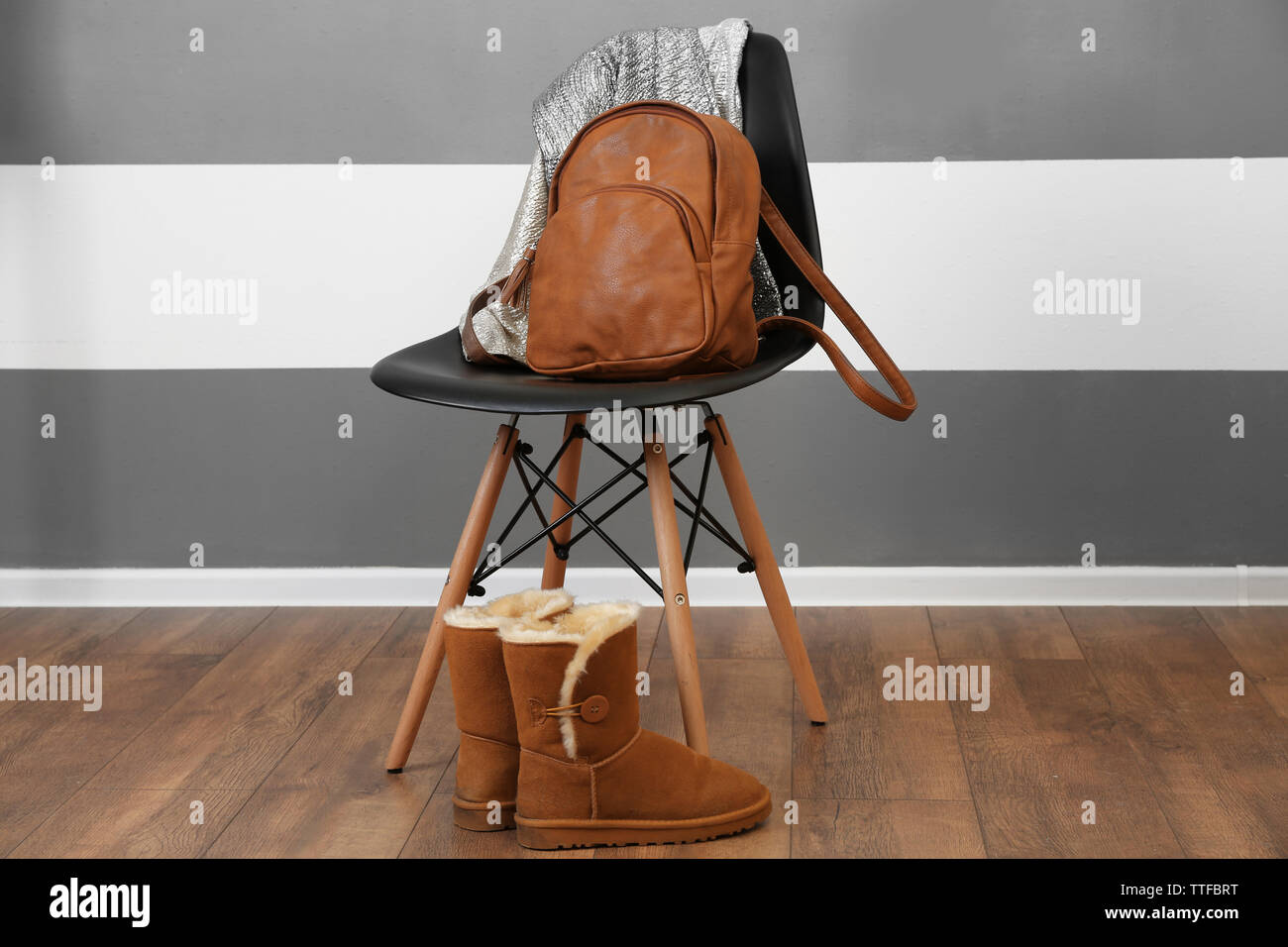 Brown leather backpack and shirts on chair near boots indoors Stock ...