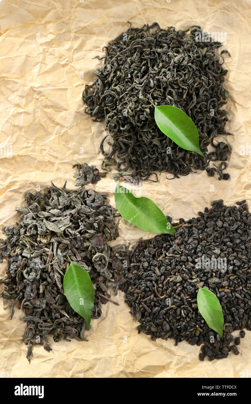 Dry tea with green leaves on beige paper background Stock Photo - Alamy