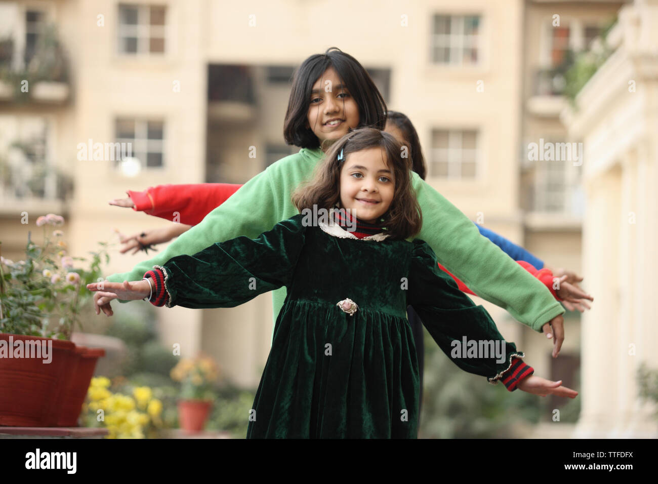 Girls standing with arms outstretched in a row Stock Photo - Alamy