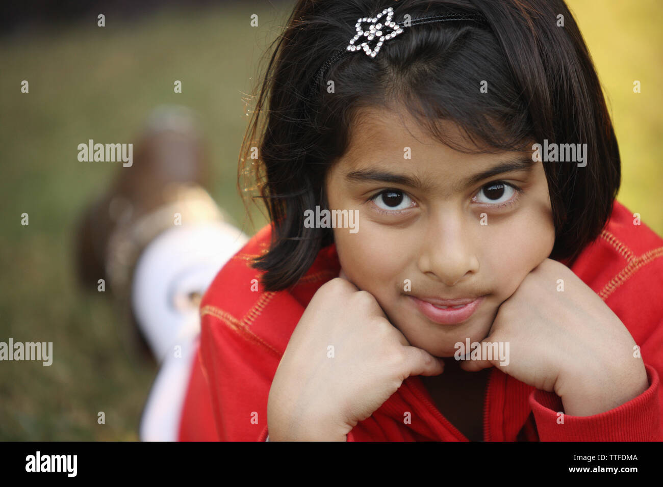 Portrait of a girl leaning on elbows Stock Photo - Alamy