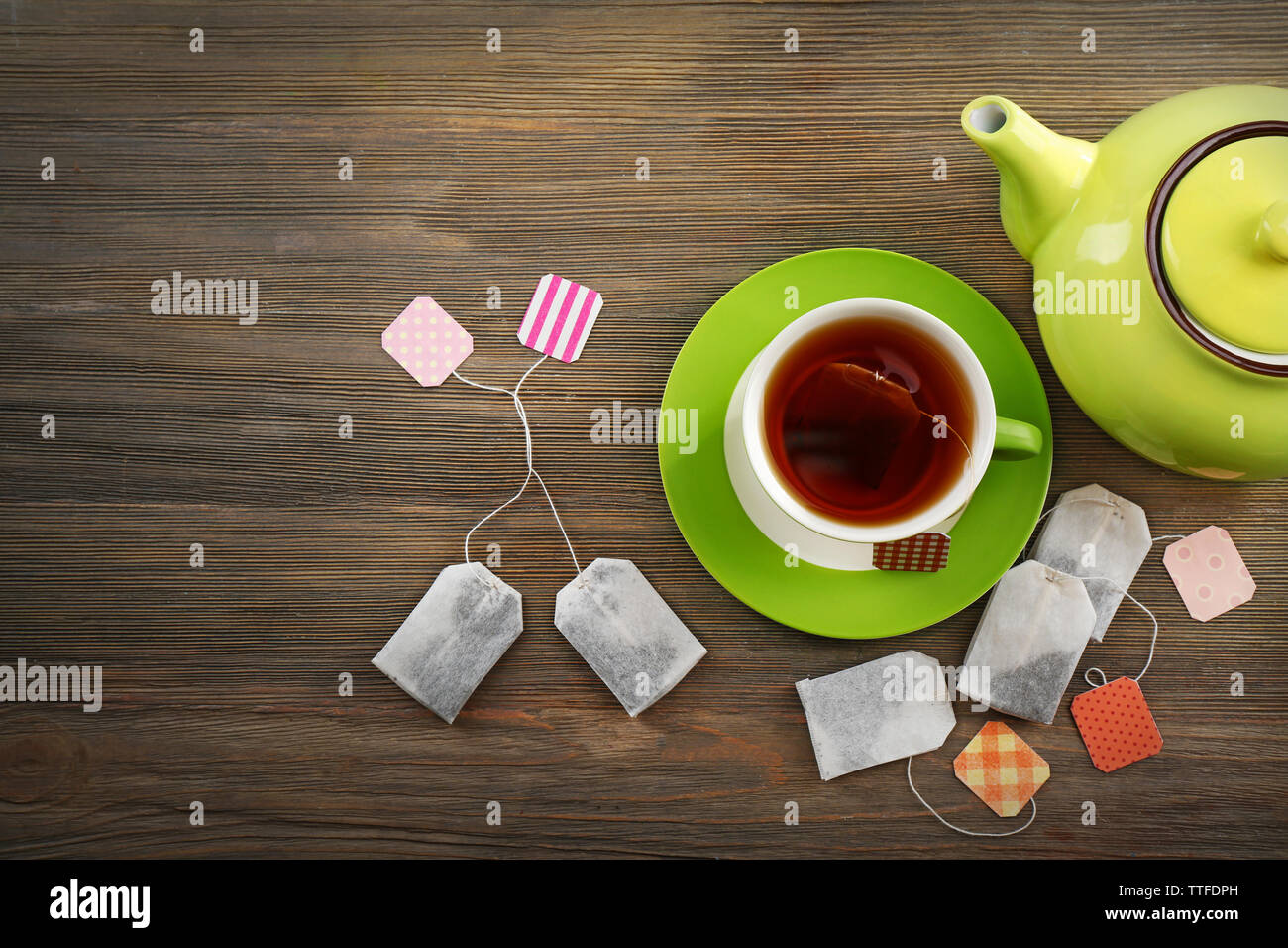 Cup of tea with tea bags and teapot on wooden table background Stock ...