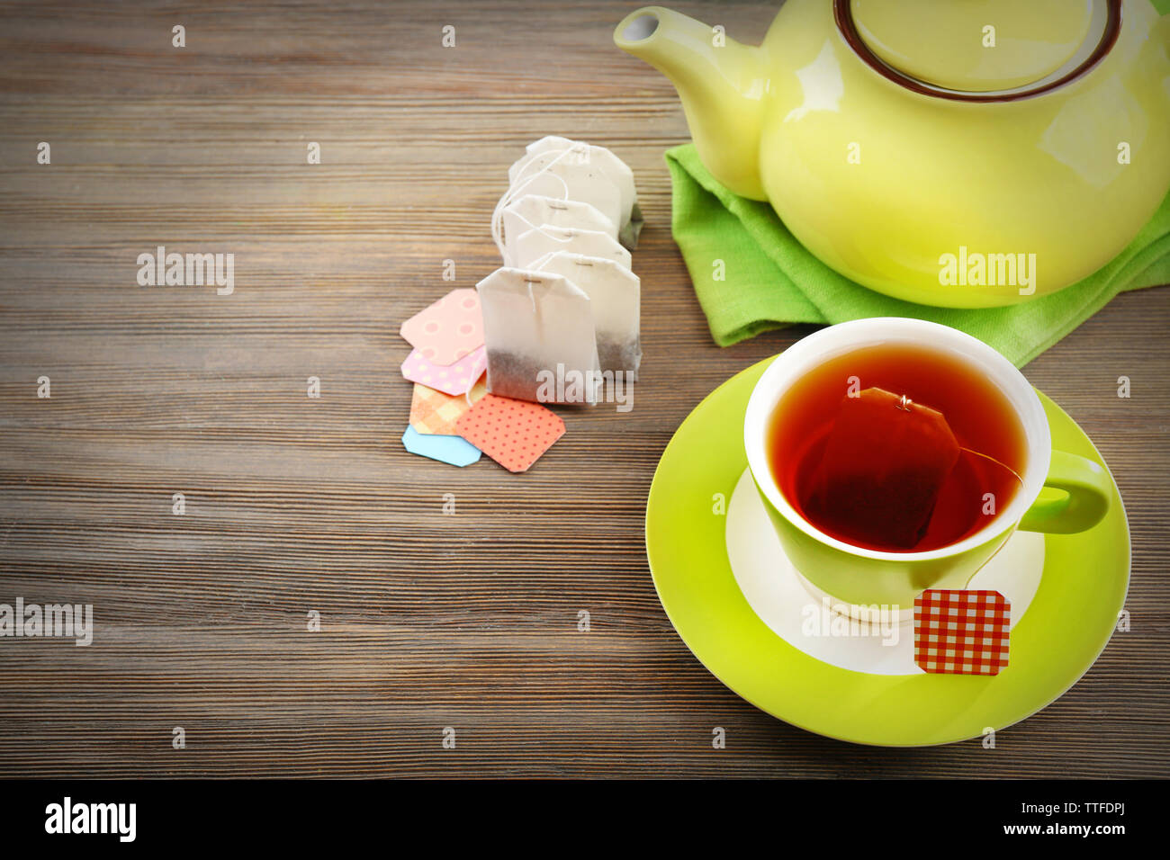 Cup of tea with tea bags and teapot on wooden table background Stock ...