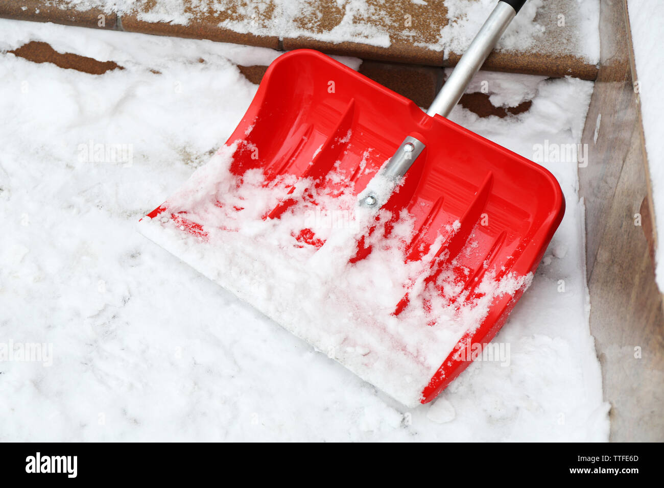 Red shovel for snow removal beside stairs Stock Photo - Alamy