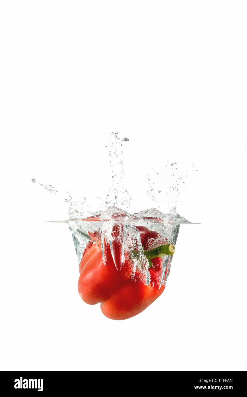 Red pepper sprinkles the water on a white background Stock Photo - Alamy