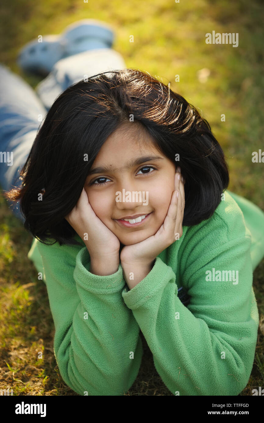 Portrait of a girl lying on grass Stock Photo - Alamy