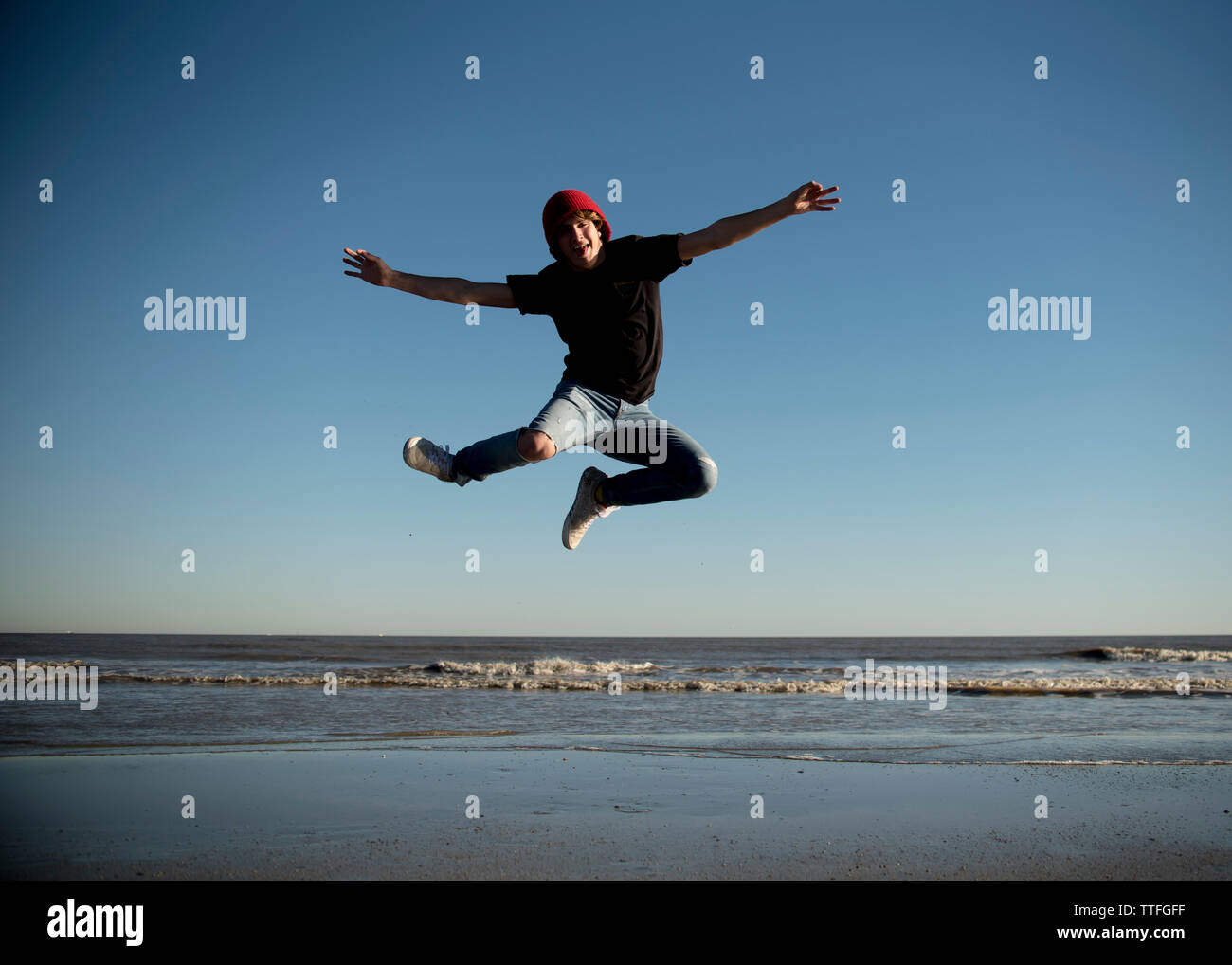 Happy teenage boy jumping on the beaches of Galveston, Texas Stock ...
