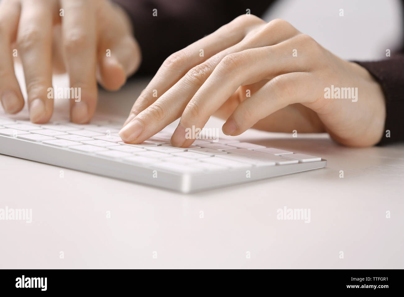 Female hands using keyboard on white wooden table, close up Stock Photo - Alamy