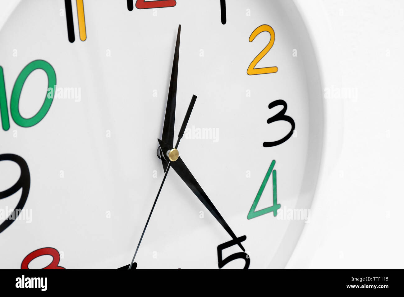 Round wall clock with colorful figures, close up Stock Photo - Alamy