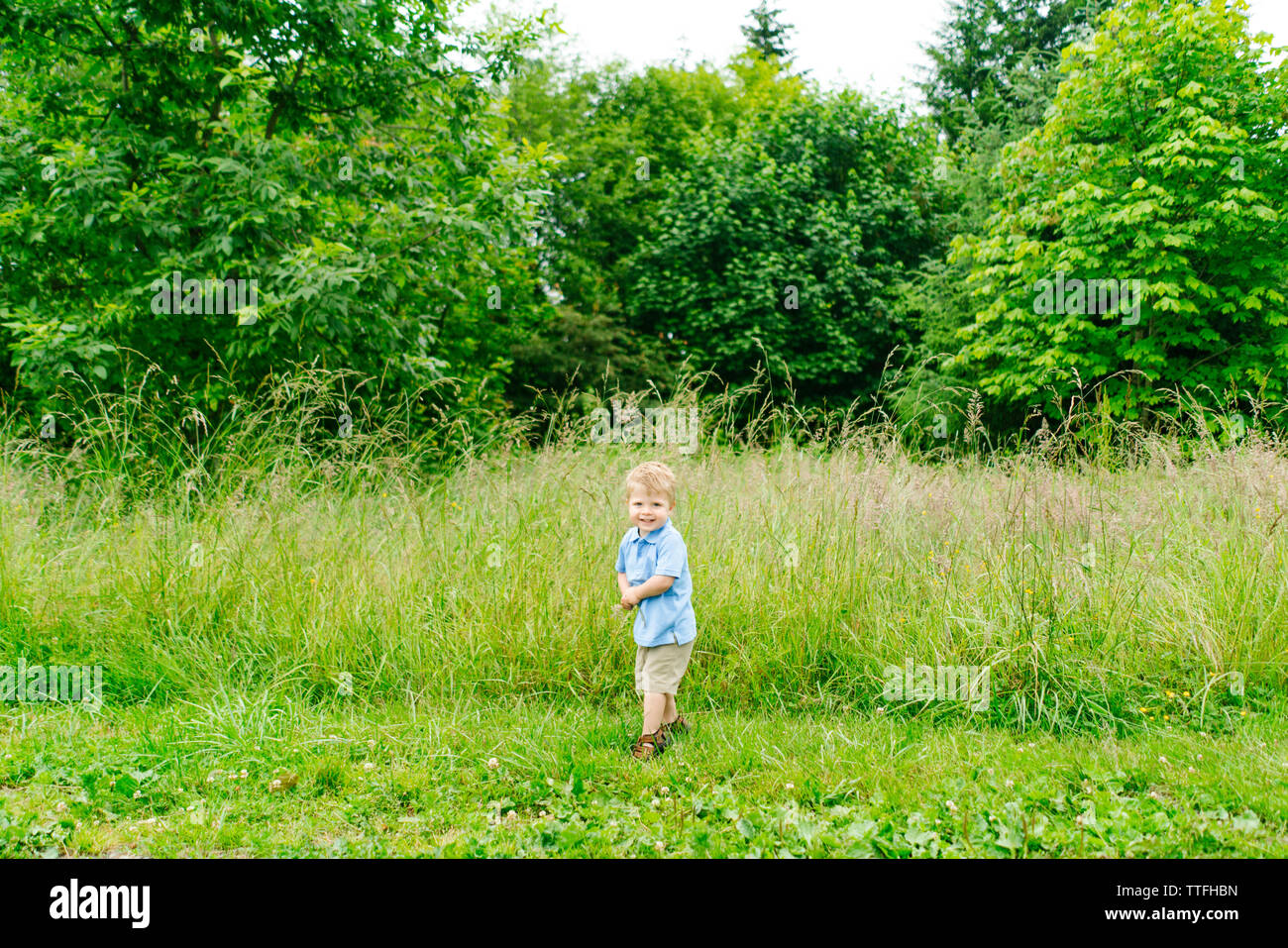 Straight on portrait of a young boy smiling outside Stock Photo - Alamy