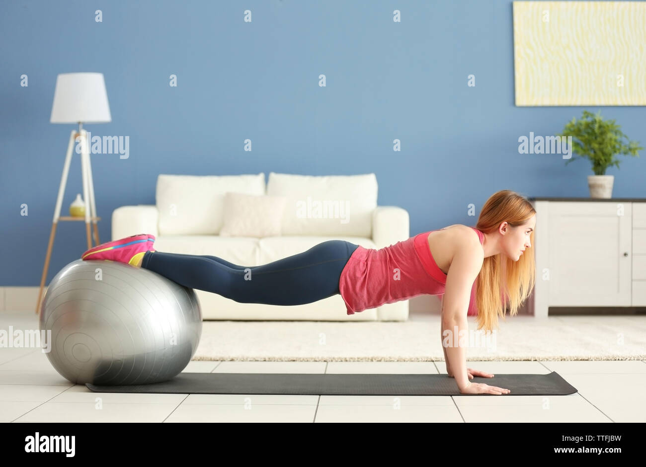 Young sportswoman doing exercises with ball on a mat at home Stock ...