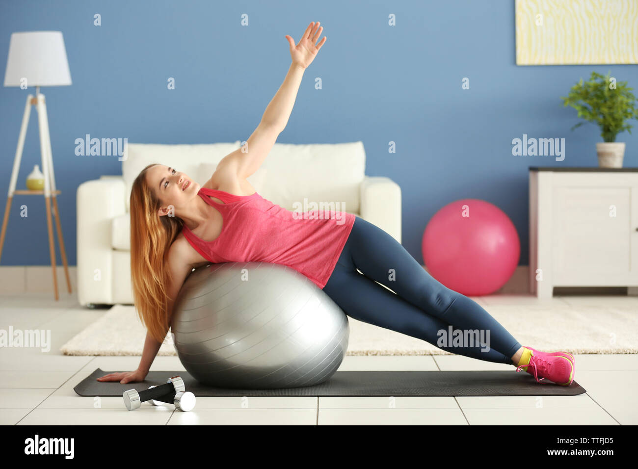 Young sportswoman doing exercises with ball on a mat at home Stock ...