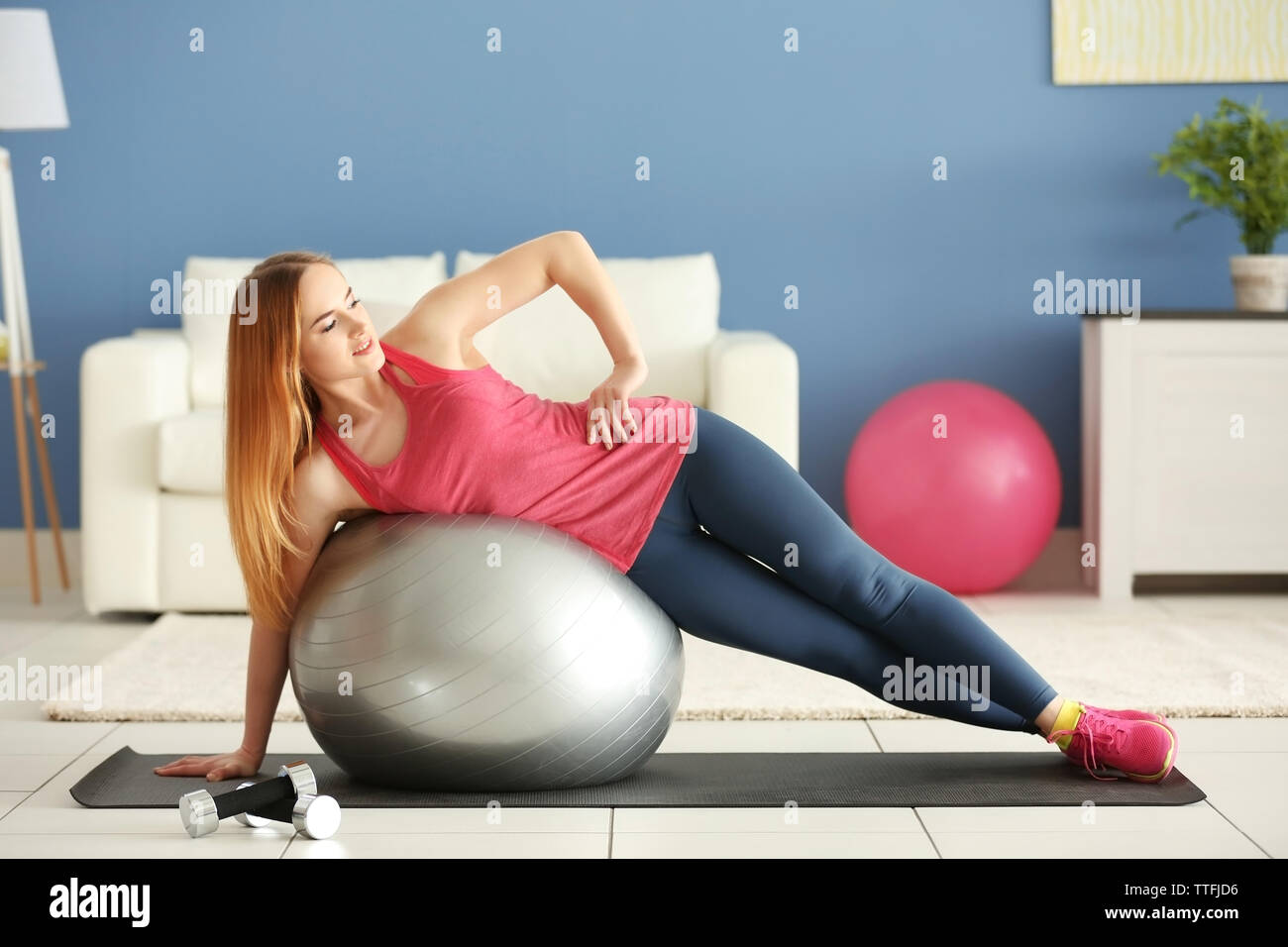 Young sportswoman doing exercises with ball on a mat at home Stock ...