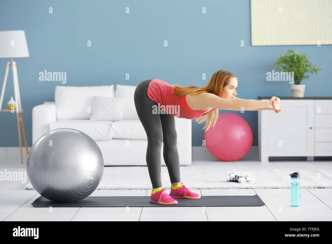 Young sportswoman doing exercises with ball on a mat at home Stock ...