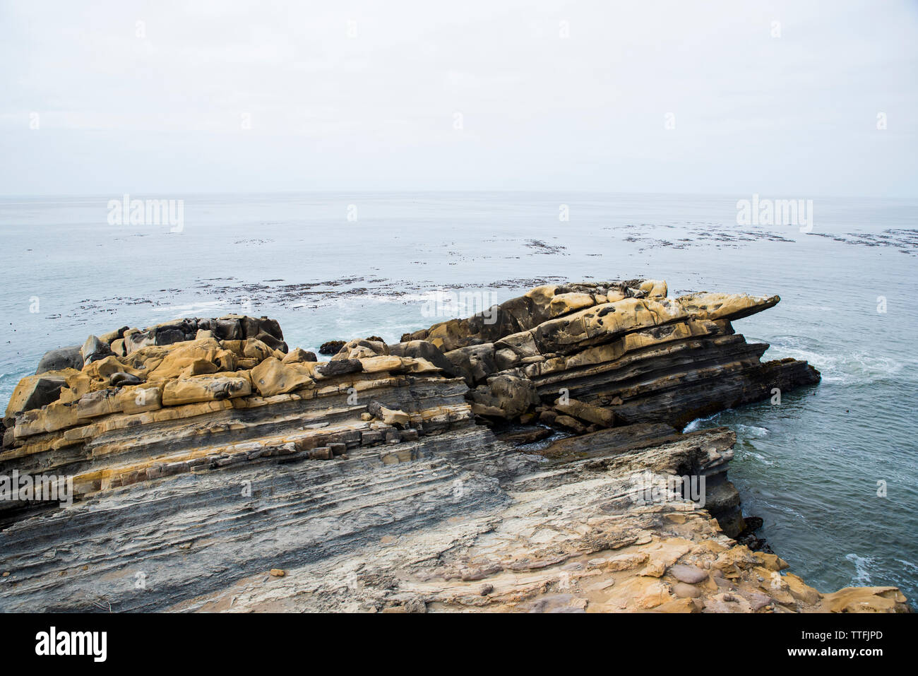 Stone outcropping extending out into the ocean Stock Photo - Alamy
