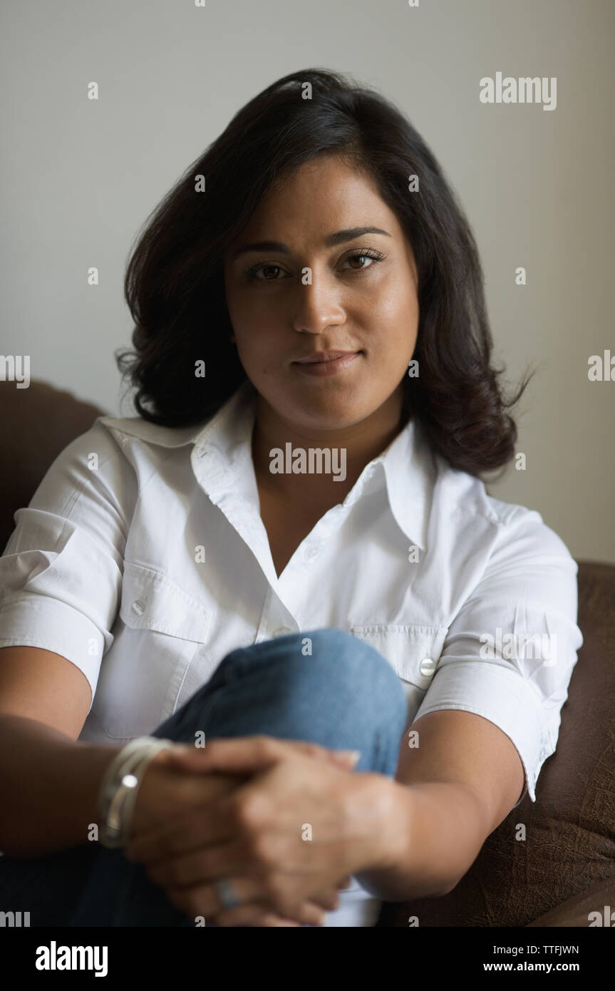 Portrait of a woman sitting on a couch Stock Photo - Alamy