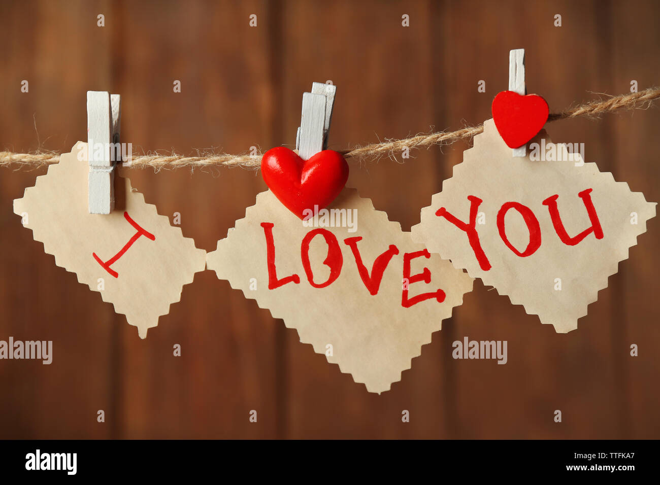 Valentine's Day card with hearts and words of love on wooden background ...
