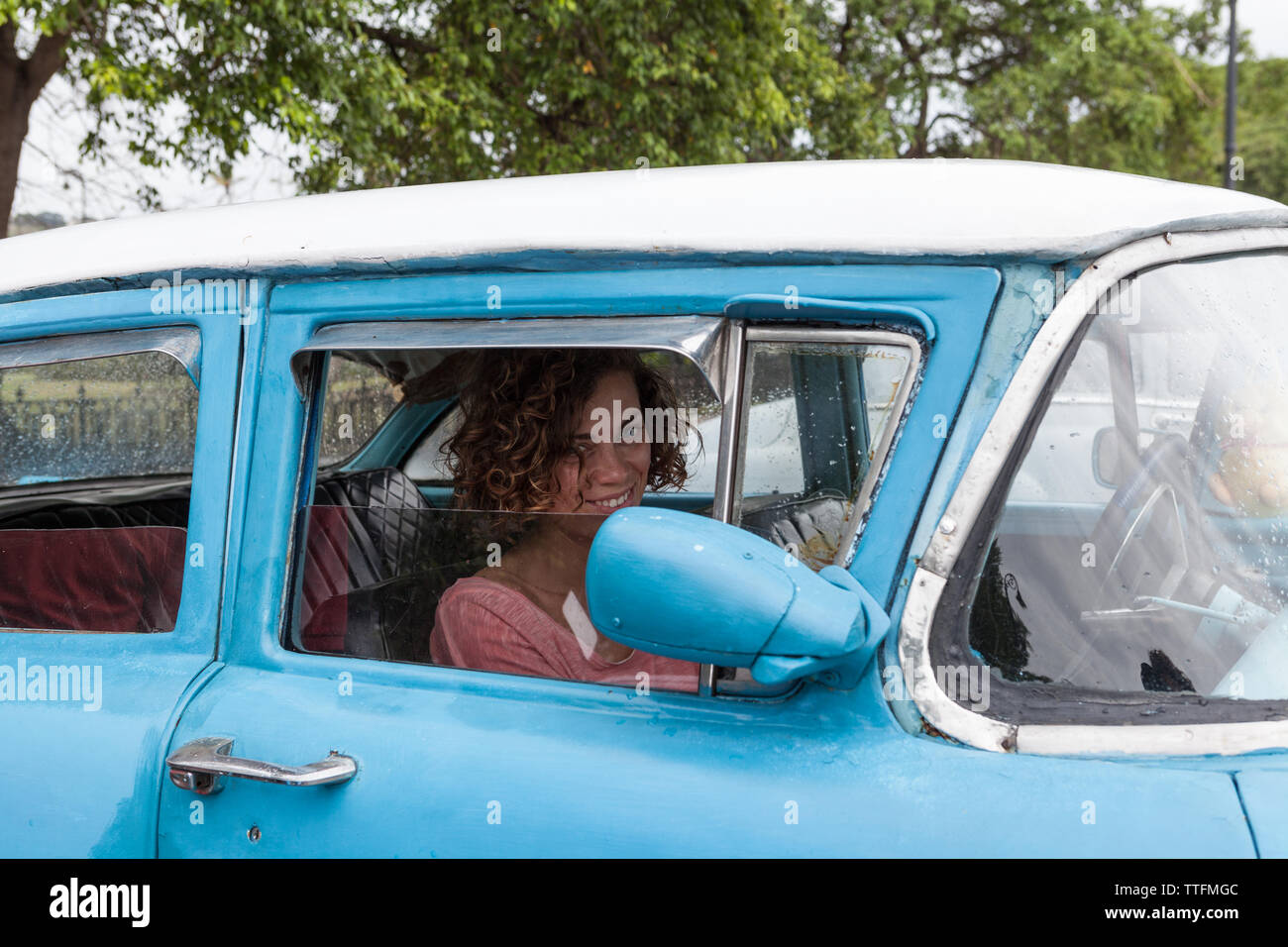 Western beautiful girl smiling inside a old vintage car. Havana, Cuba ...