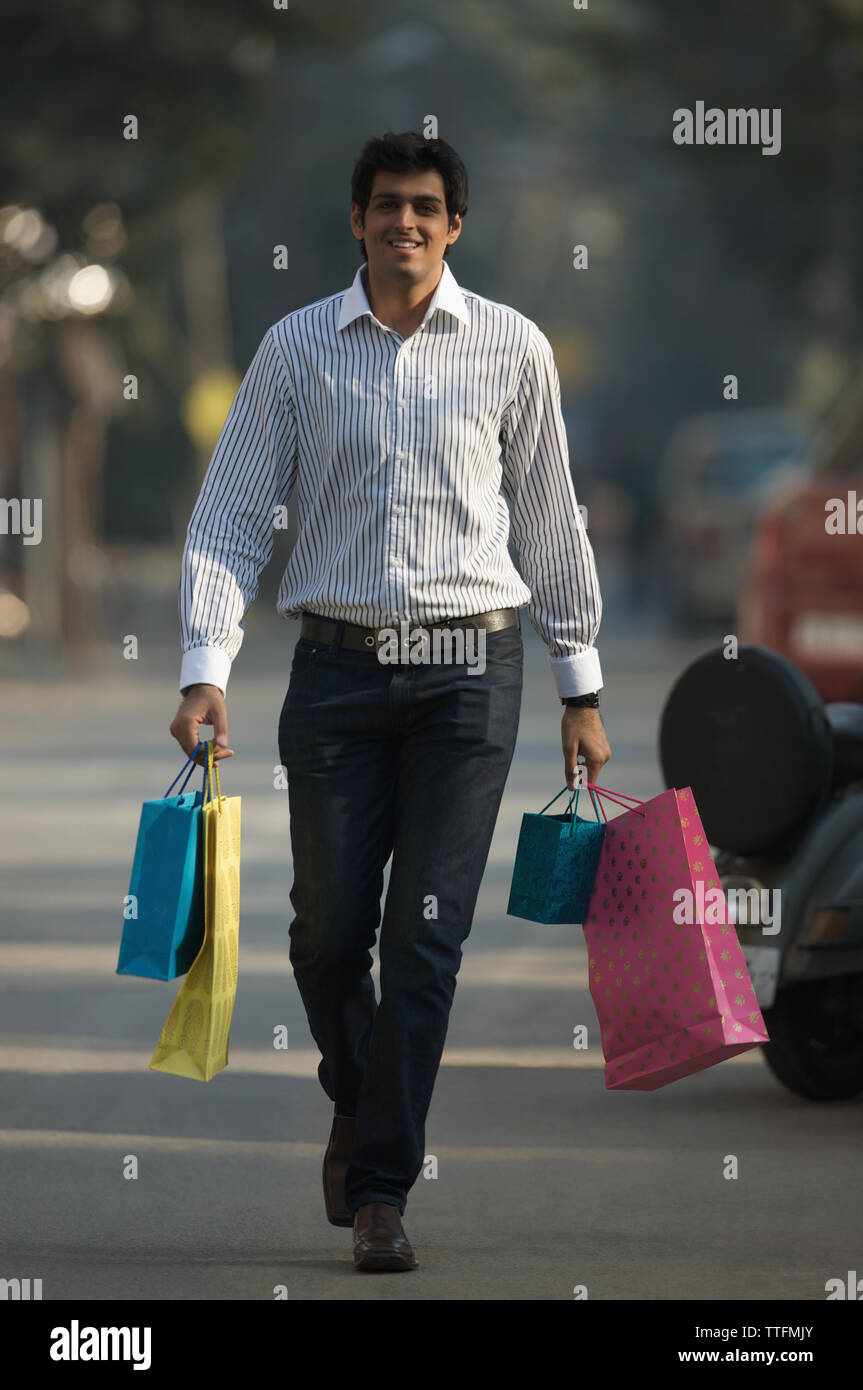 Man carrying shopping bags and smiling Stock Photo - Alamy