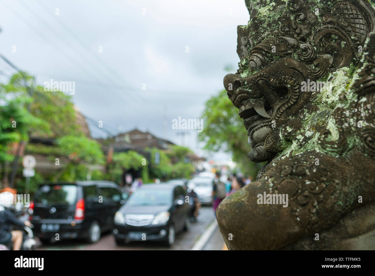 Balinese demon god statue with traffic in the background, Ubud Bali ...