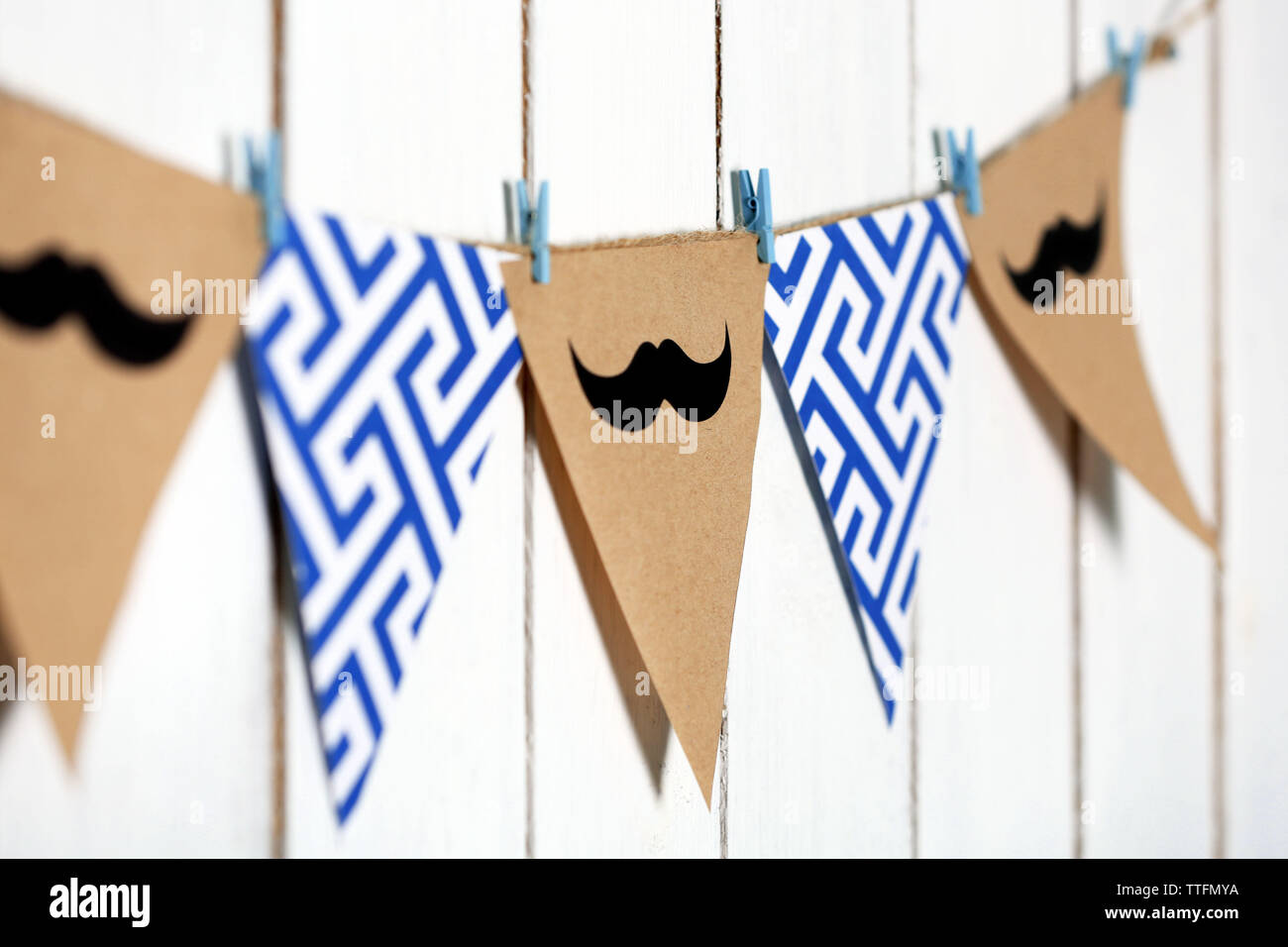 Hanging flags with mustaches on wooden background Stock Photo - Alamy