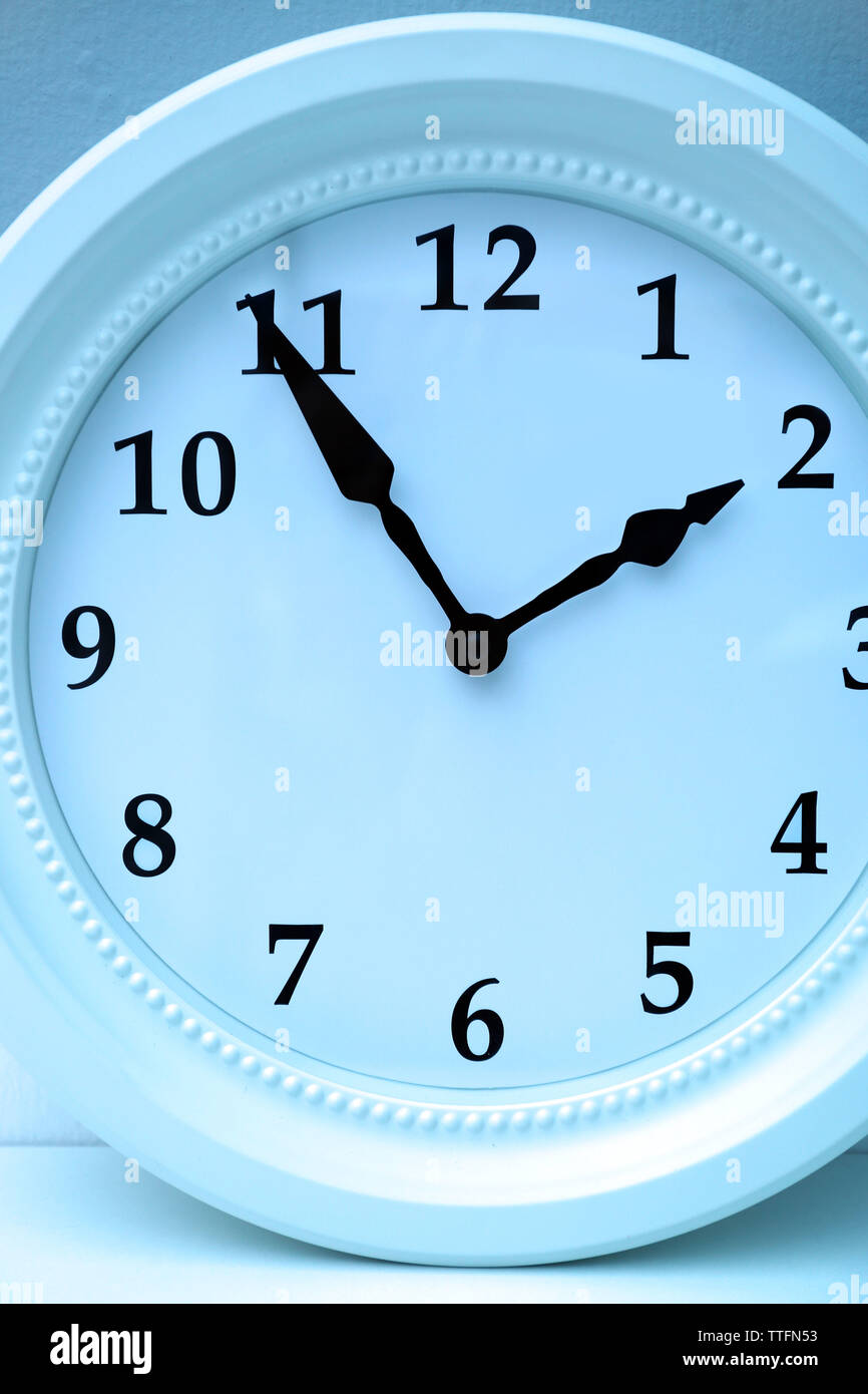 Clock face in blue light closeup Stock Photo - Alamy