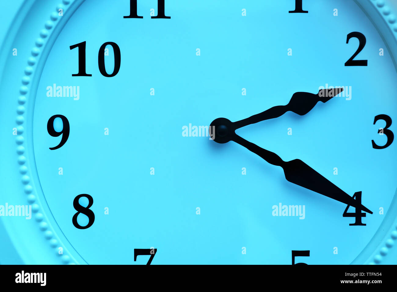 Clock face in blue light closeup Stock Photo - Alamy