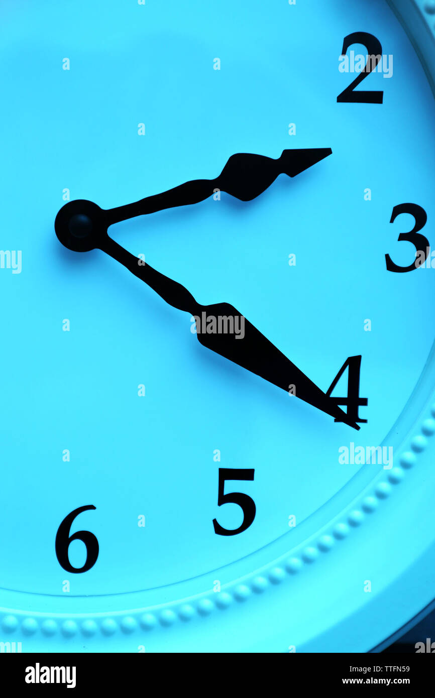 Clock face in blue light closeup Stock Photo - Alamy