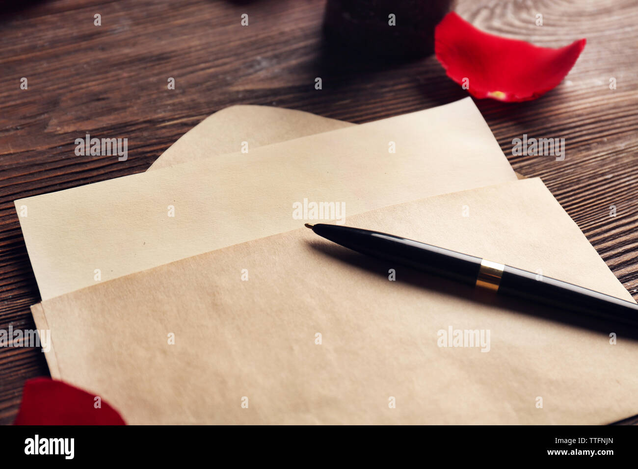 Gift card for Valentine's Day with pen and red petal on wooden ...