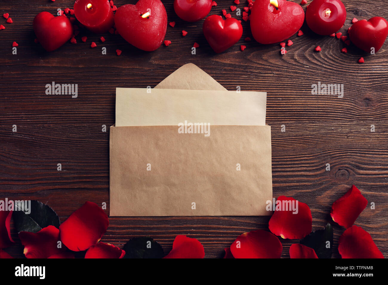 Gift card for Valentine's Day with candles and red petals on wooden ...