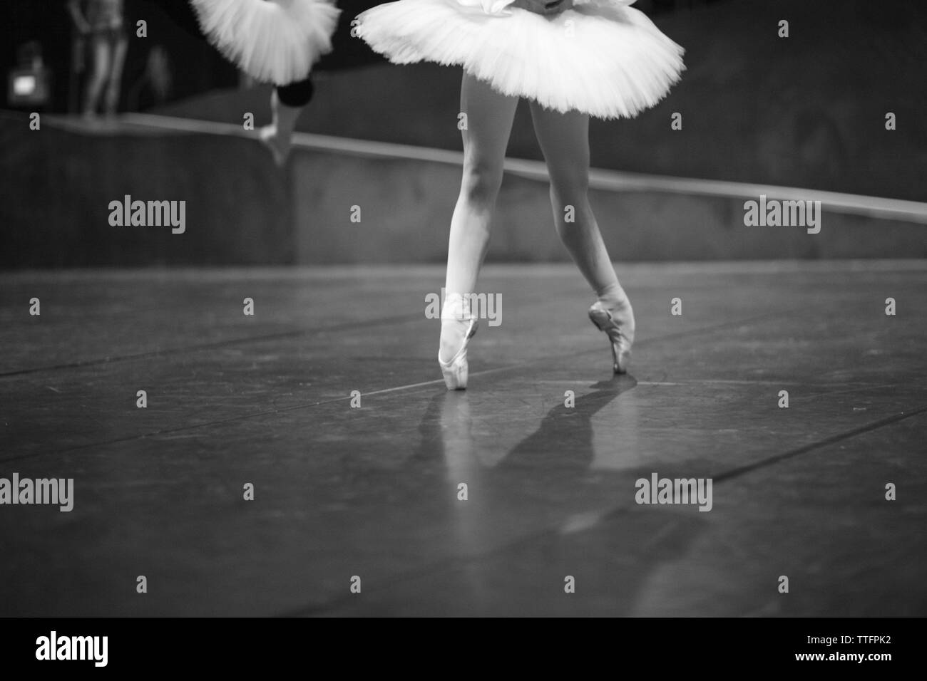 Elegant legs of a ballerina standing on pointe on stage during a ...