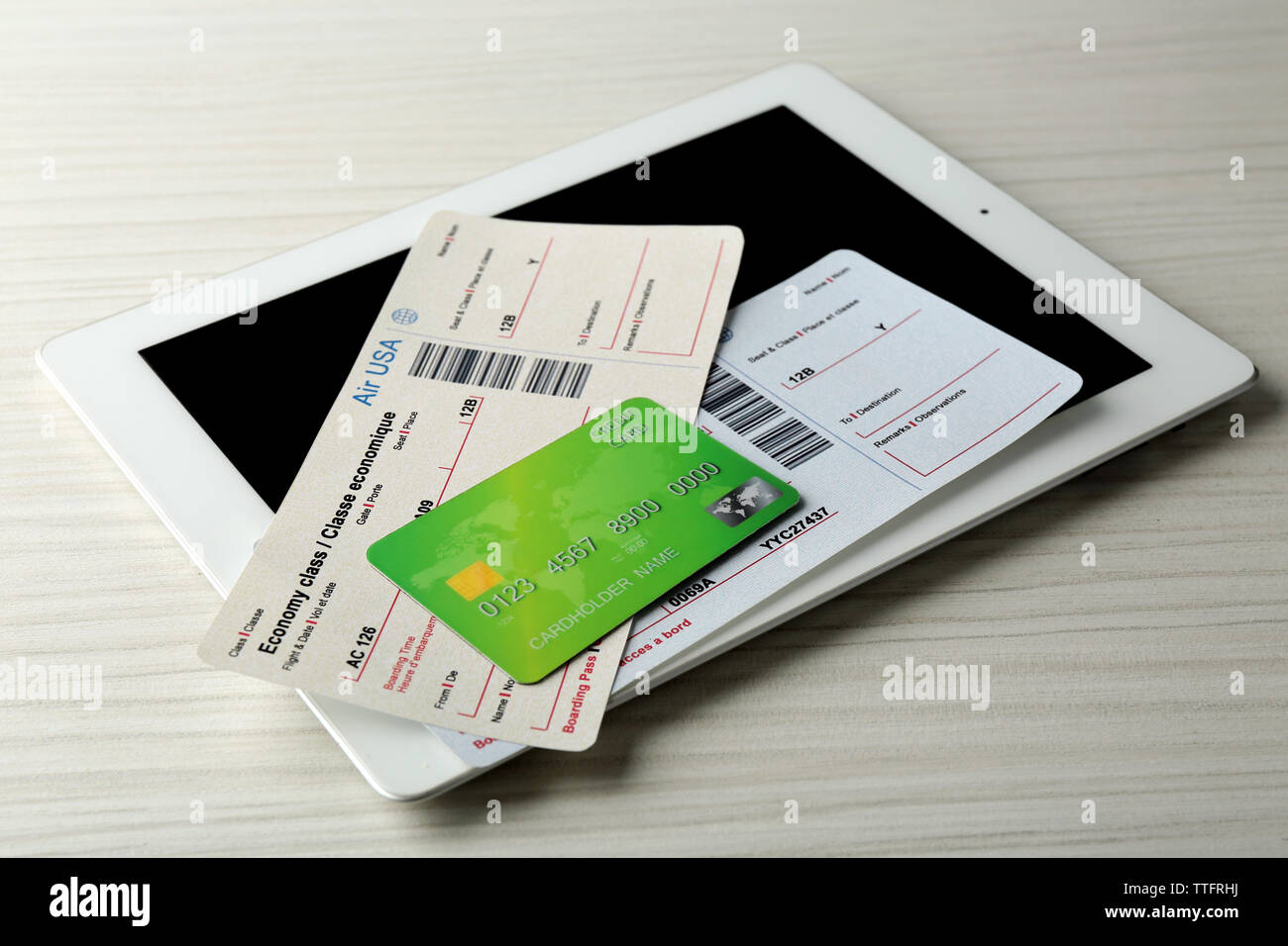 Tablet with credit card and flight tickets on light wooden table Stock ...