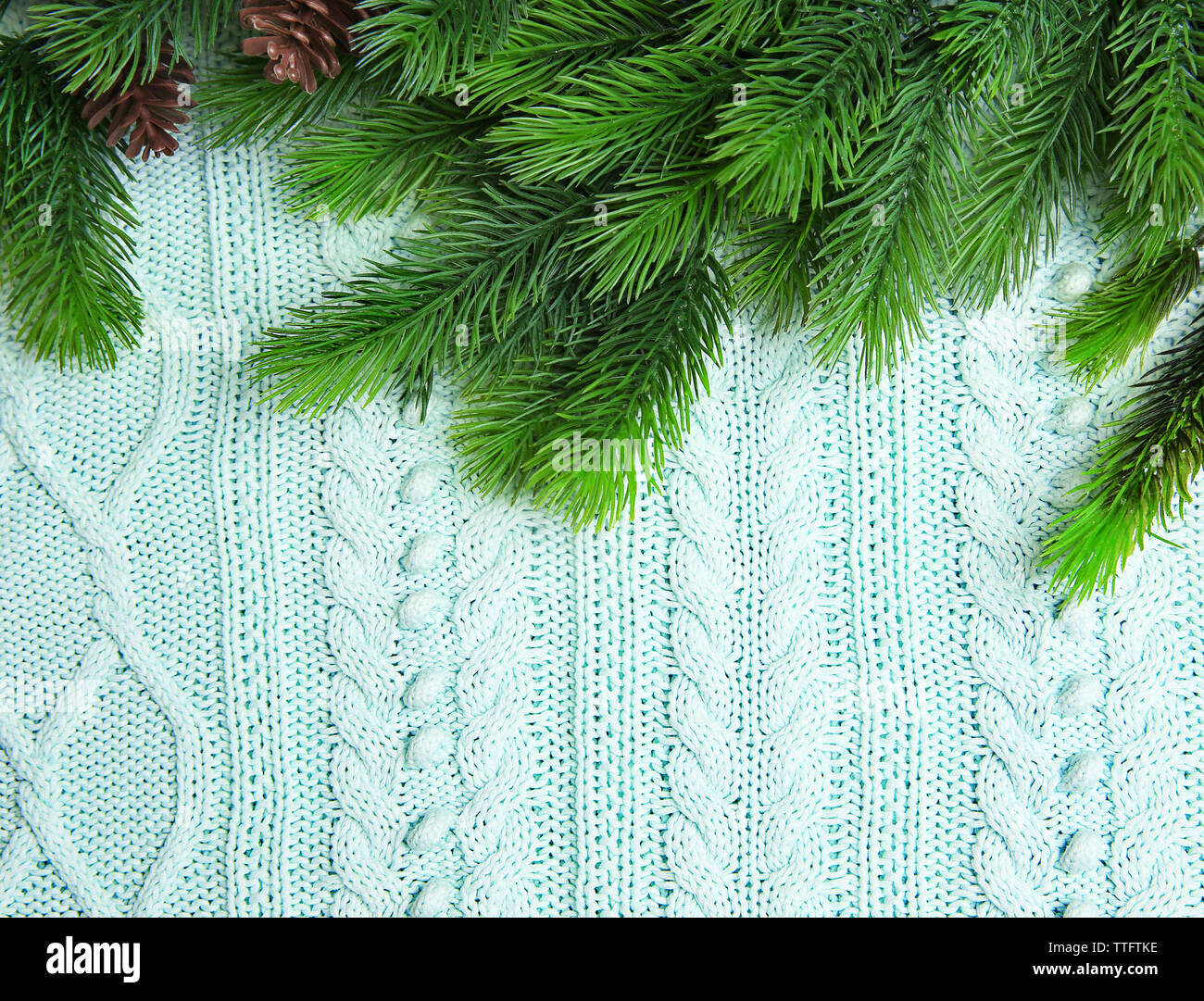 Fir twigs and cones on knitted pattern background Stock Photo - Alamy