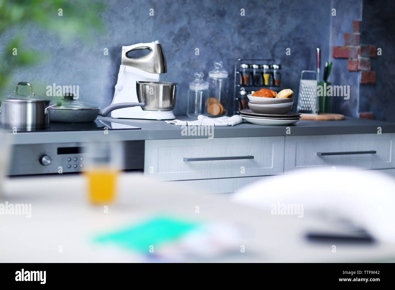 Modern white table with electric stove and utensils in the kitchen ...