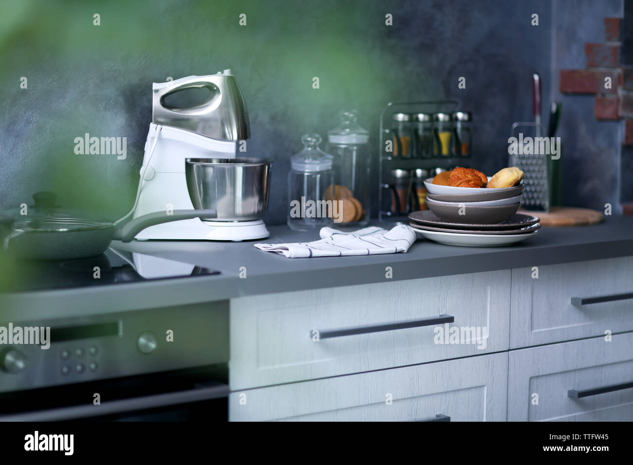 Modern white table with electric stove and utensils in the kitchen ...