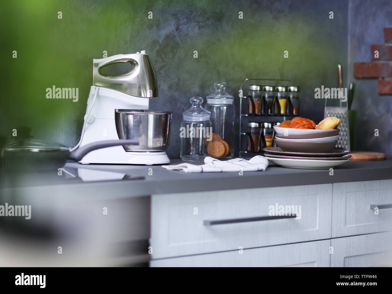 Modern white table with electric stove and utensils in the kitchen ...