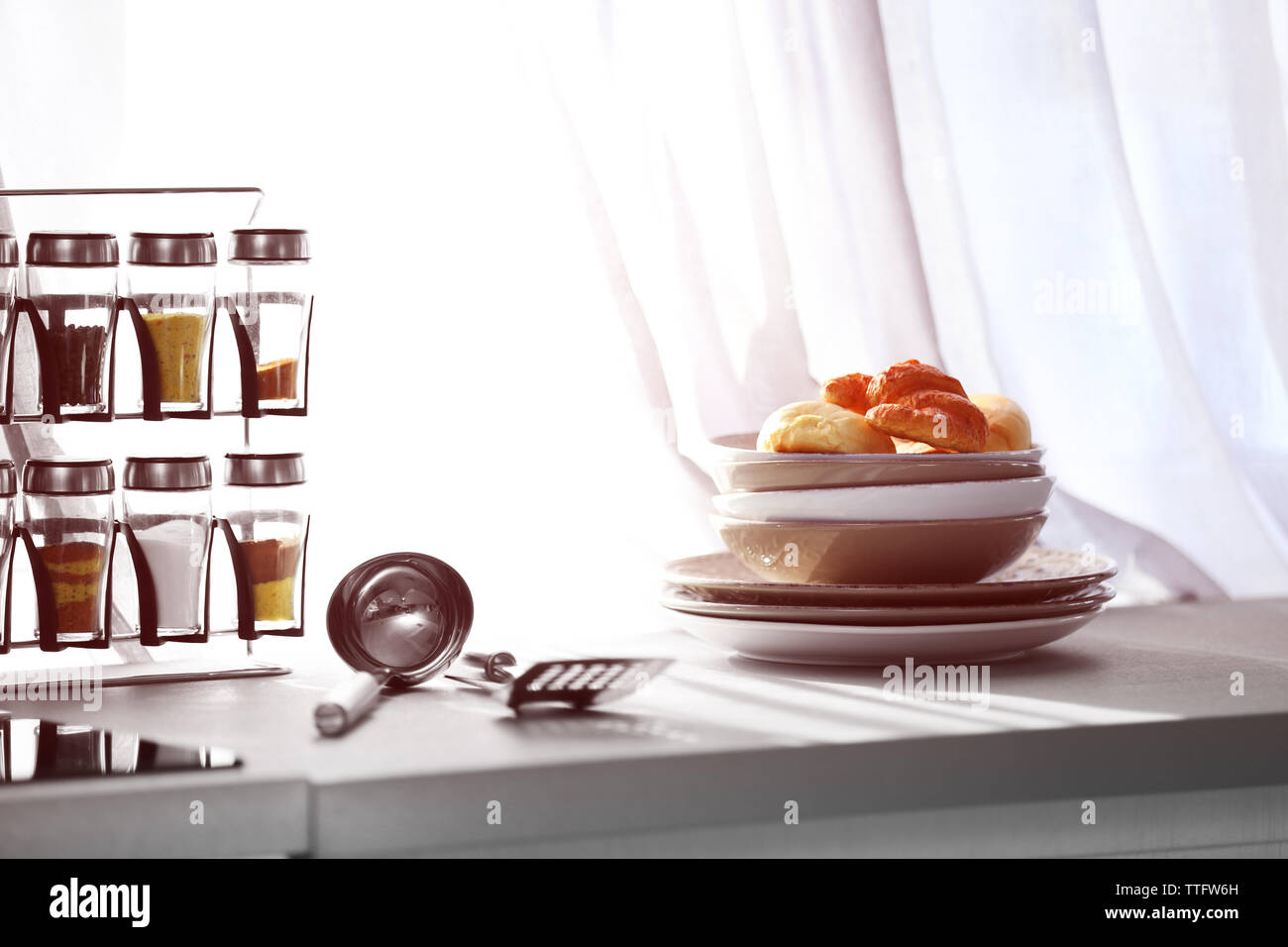 Modern kitchen table with electric stove and utensils beside the window ...