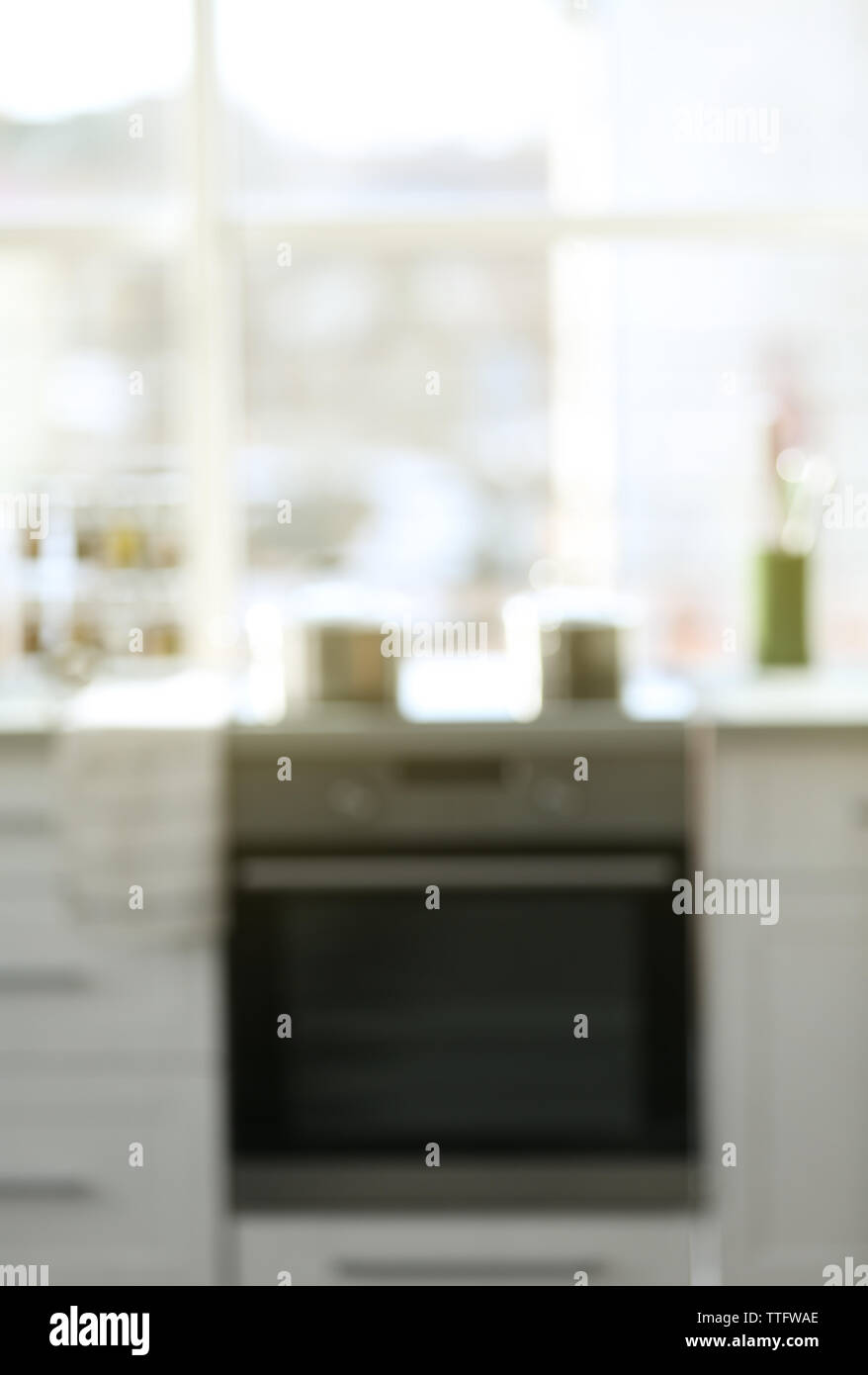 Blurred modern kitchen interior with light furniture and electric stove ...