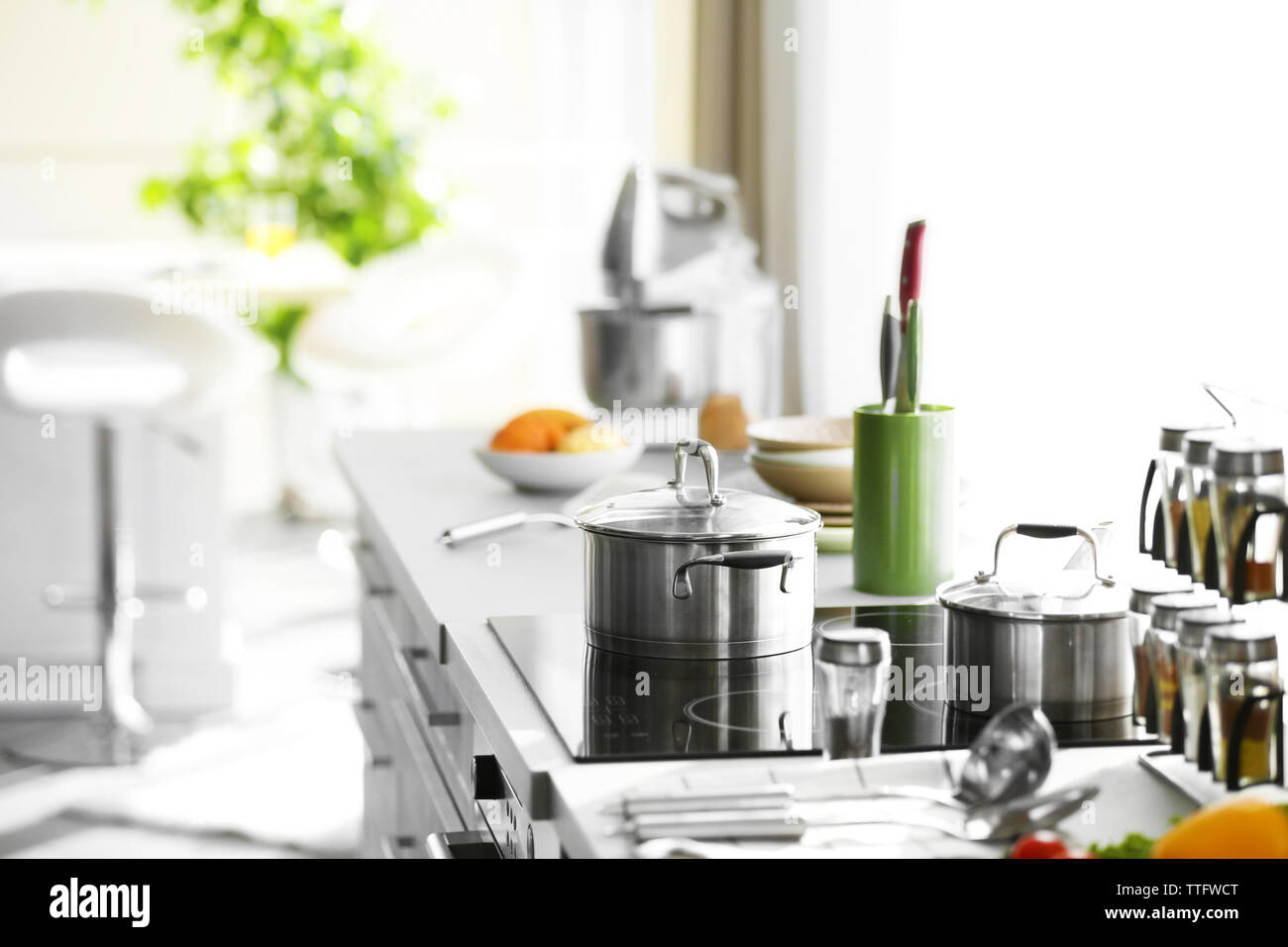 Modern table and electric stove with utensils and vegetables in the ...