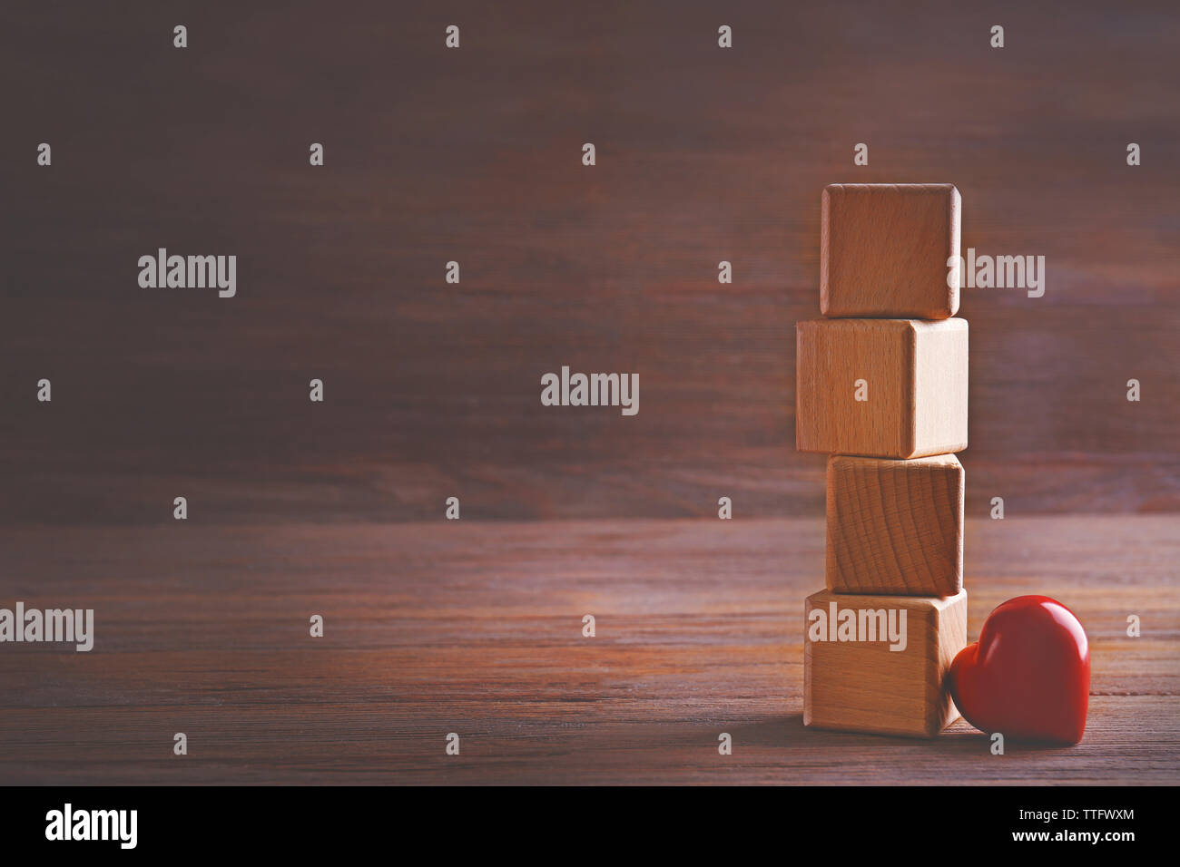 Four wooden cubes with red heart on wooden background. I love you ...
