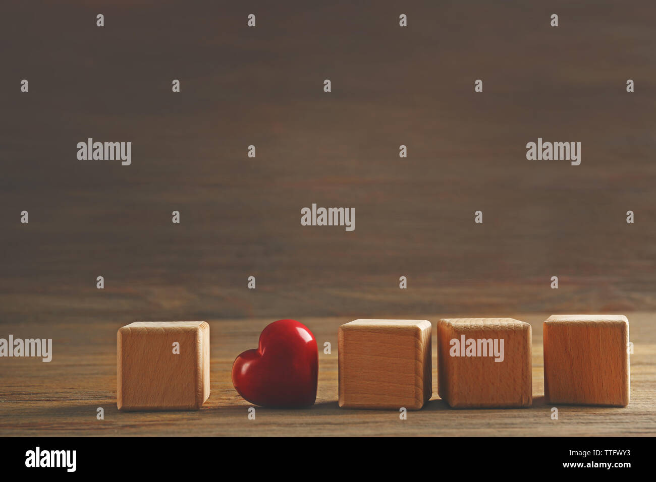 Four wooden cubes with red heart on wooden background. I love you ...