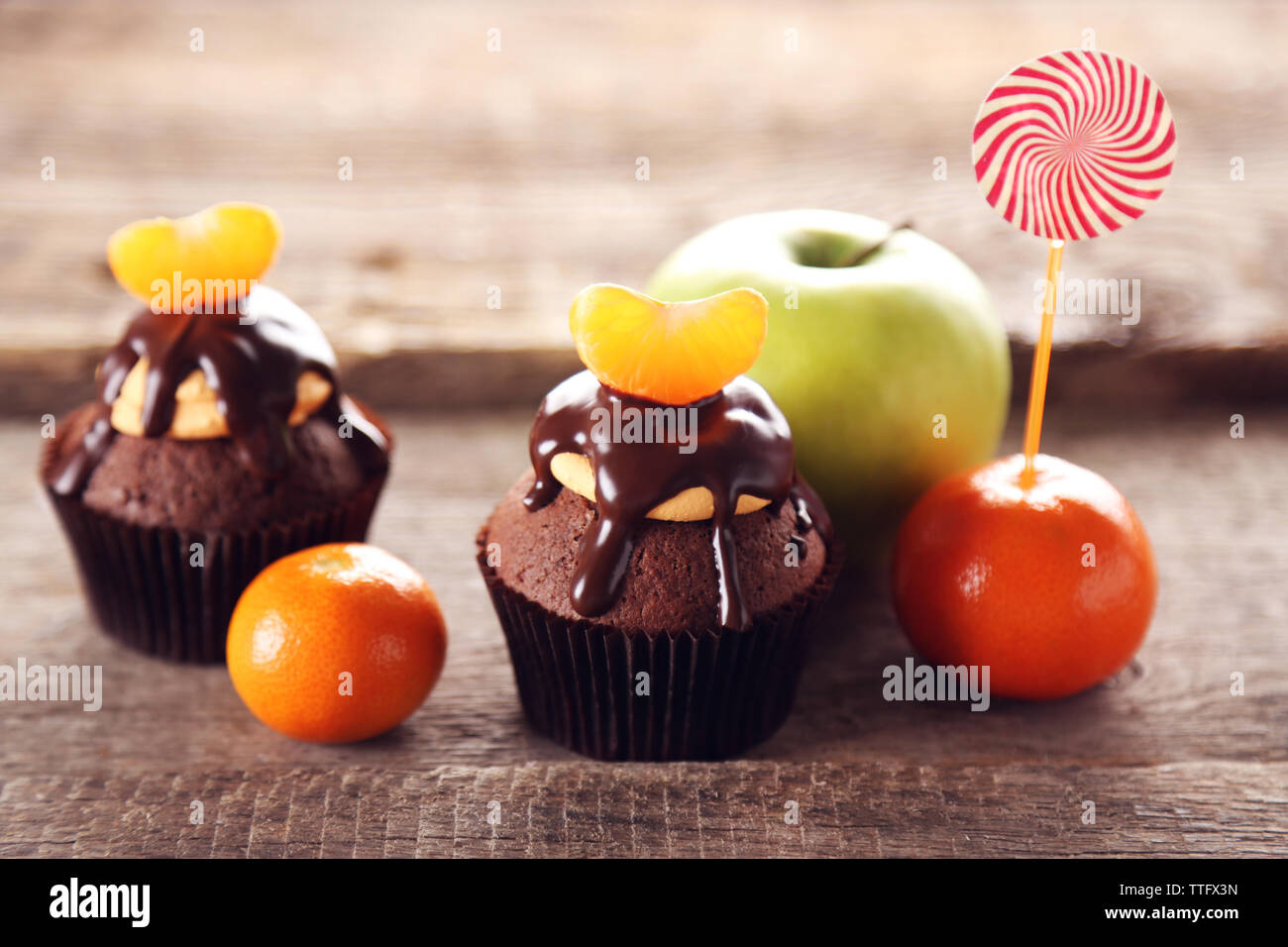 Two tasty cupcakes with fruits on wooden background Stock Photo - Alamy