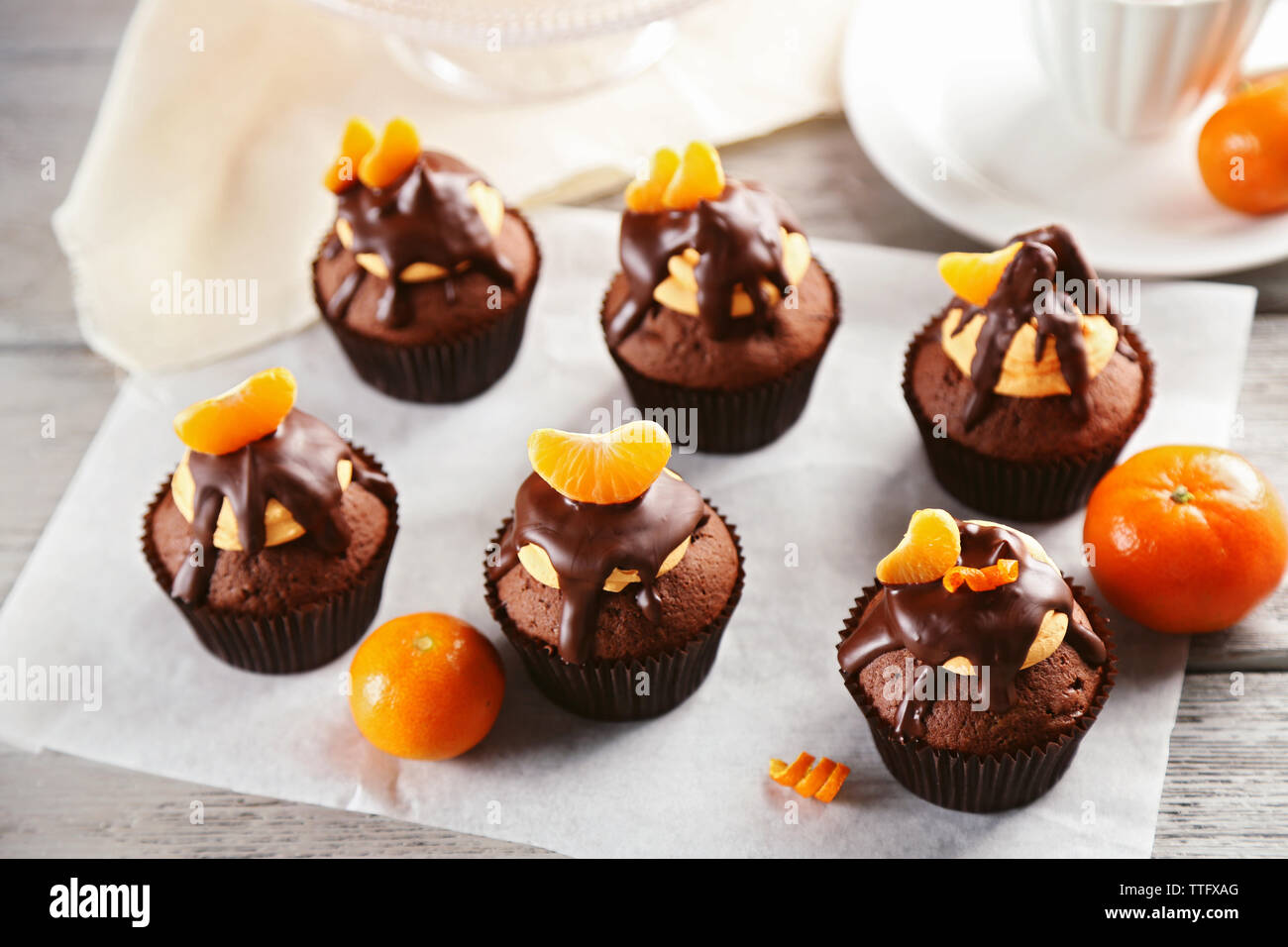 Tasty cupcakes with slice of mandarin and chocolate on a paper over ...