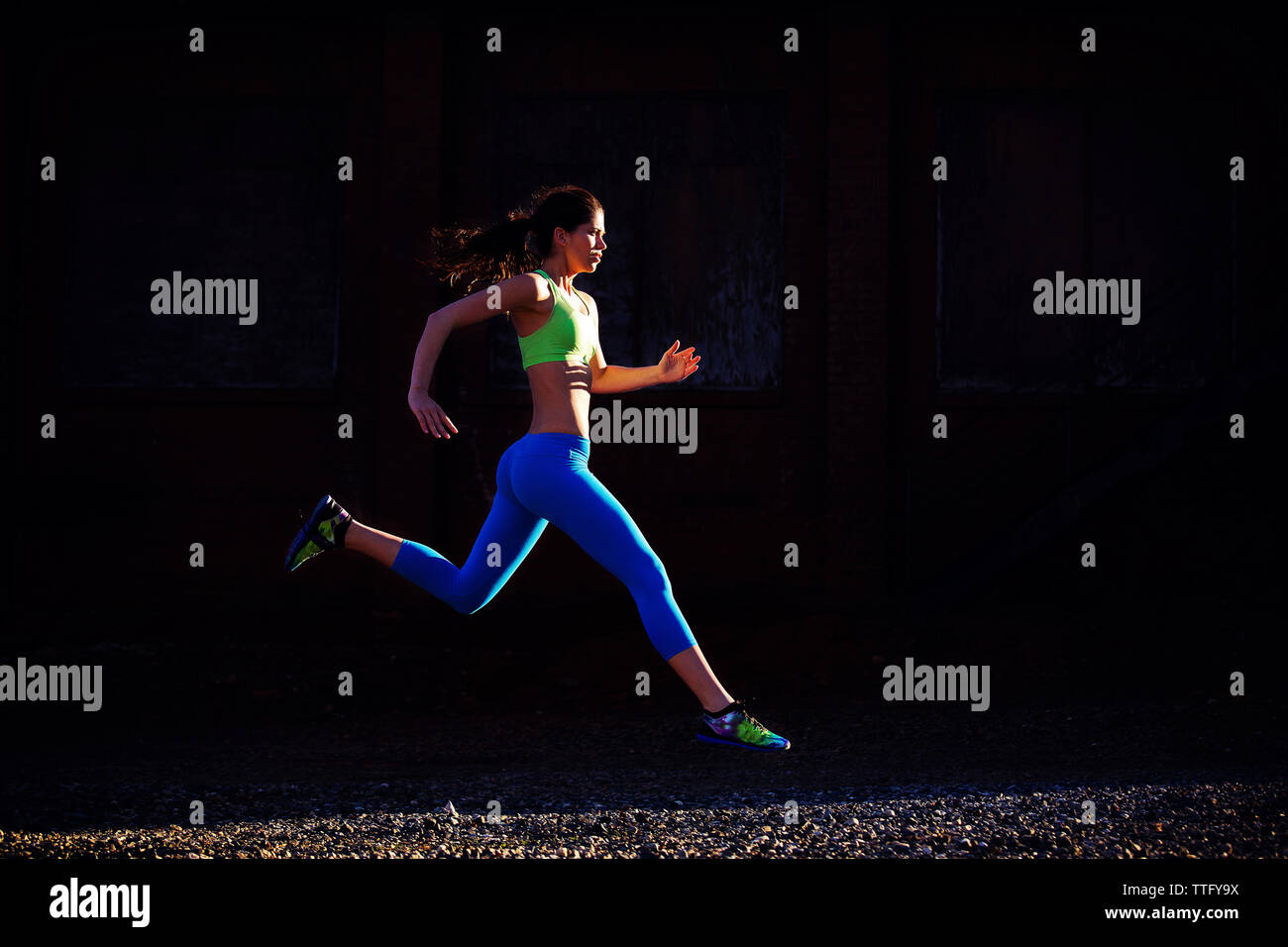 Side view of female athlete running on field Stock Photo - Alamy