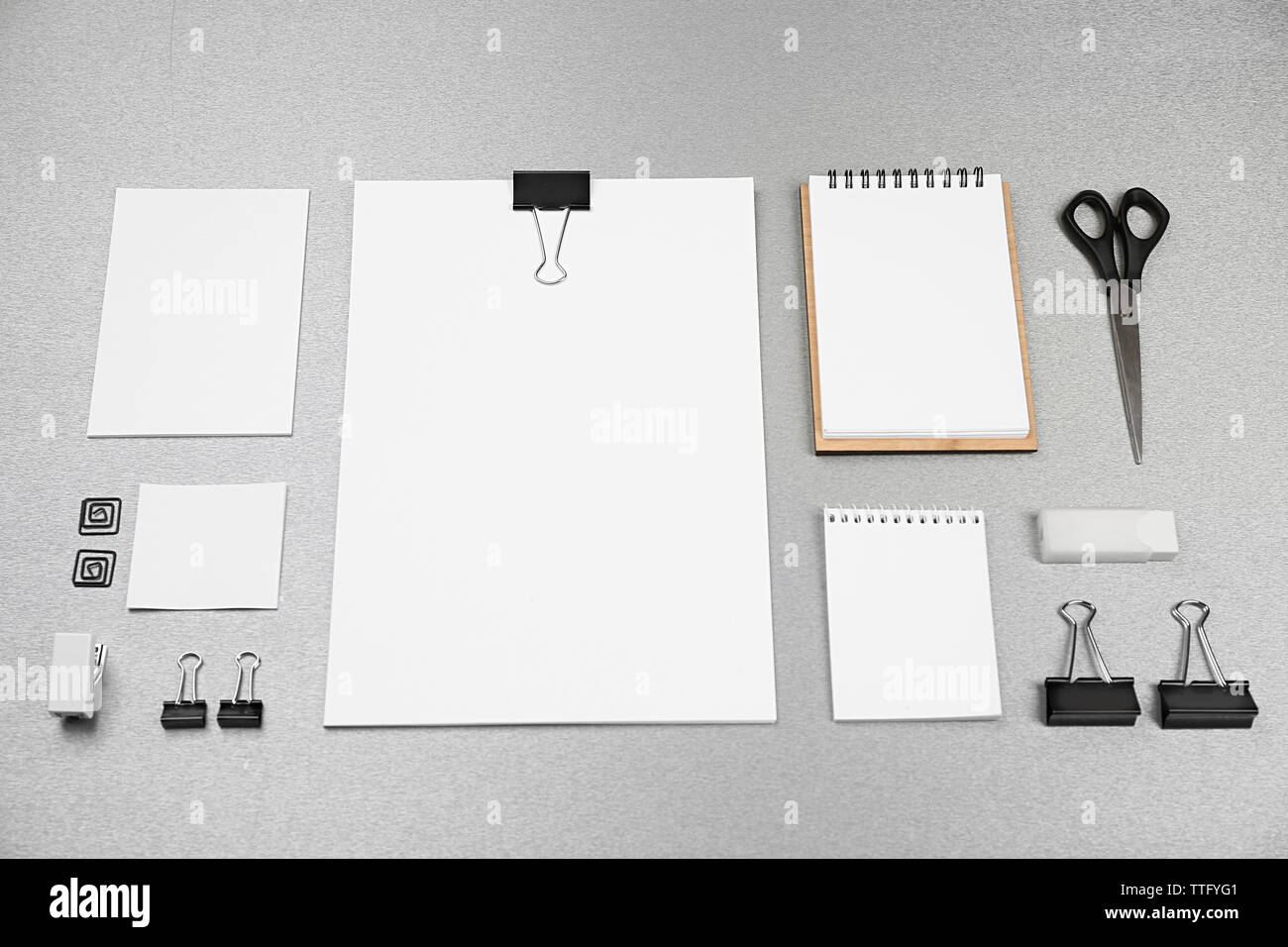 Office set with white sheets of paper, notebooks and stationery on grey ...