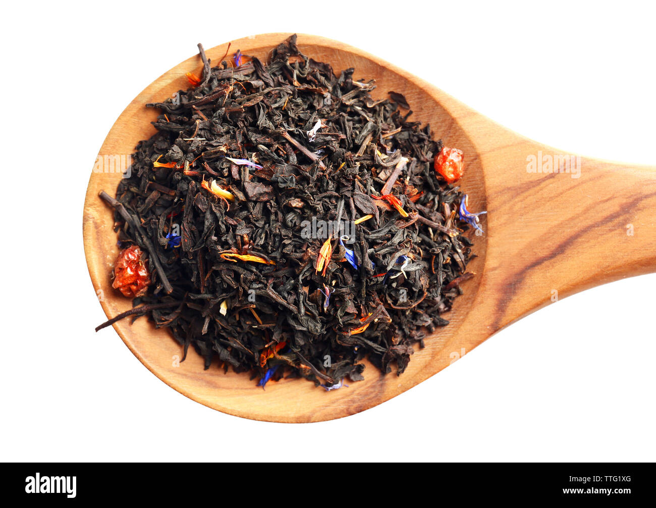Dry tea with pieces of fruits in wooden spoon, isolated on white Stock ...