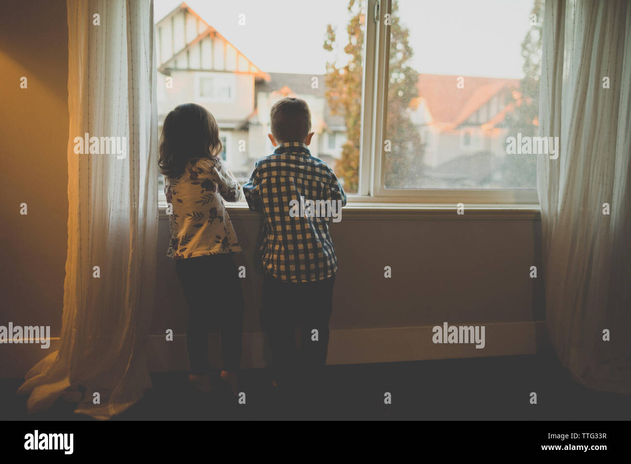 Family standing by window hi-res stock photography and images - Alamy