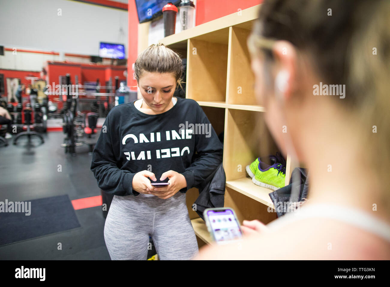female friends using mobile phone in gym Stock Photo - Alamy