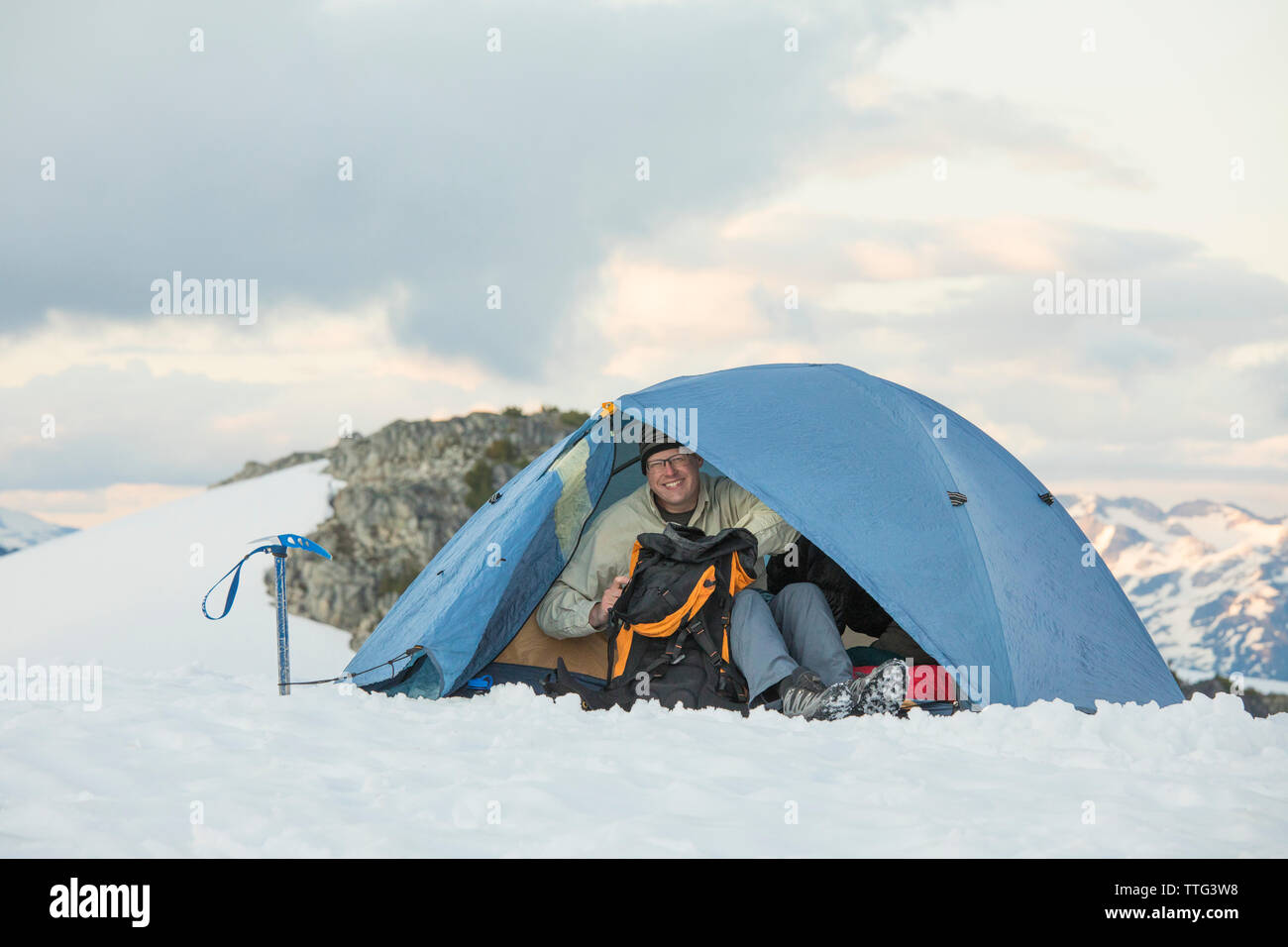 Resting mountain climber sitting in tent Stock Photo - Alamy